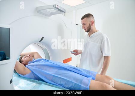Radiographer is positioning patient for computed tomography of lower ...