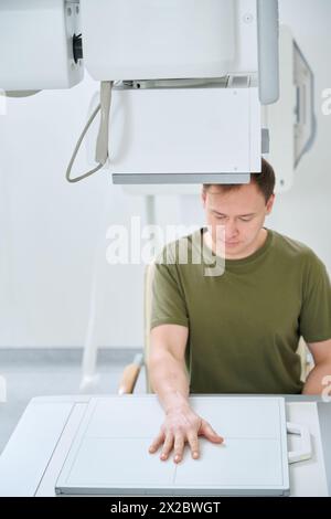 Adult man is undergoing upper extremity radiography in healthcare ...