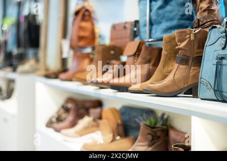 Women's boots displayed on counter in store Stock Photo - Alamy