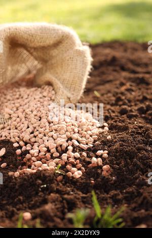 Granulated fertilizer in sack on soil, closeup Stock Photo - Alamy