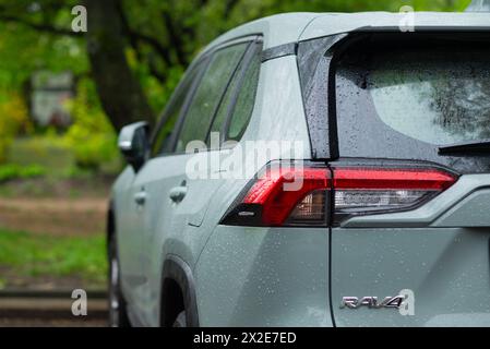 The back of a green toyota rav4 hybrid car with a sign or logo with ...