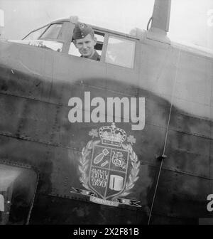 A flight crew member sits on the steps of a Fleet Logistics Support ...