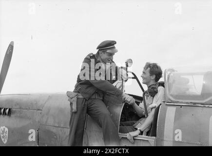 Pilots of No. 602 Squadron RAF study target maps and photographs in the ...
