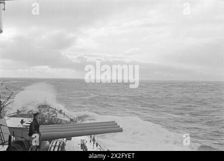 The fore guns of 'A' turret on HMS King George V are visible with sea ...