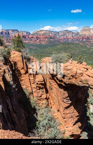 Hikers cross the Devil's Bridge natural arch along the Devil's Bridge ...