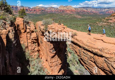 Hikers cross the Devil's Bridge natural arch along the Devil's Bridge ...