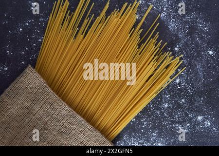 zenithal shot of a bunch of dried spaghetti inside a rustic bag on a ...