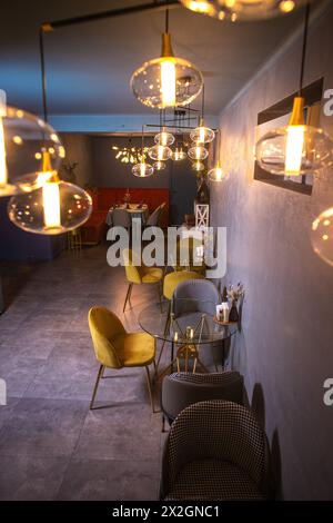 Elegant restaurant with dim lighting, stylish furniture, dark walls ...