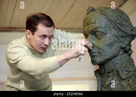 Sculptor works in the studio with a plasticine model of the bust Stock ...