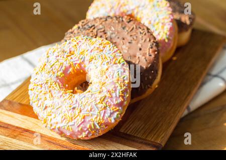 Ring frosting doughnuts with topping on pink backdrop Stock Photo - Alamy