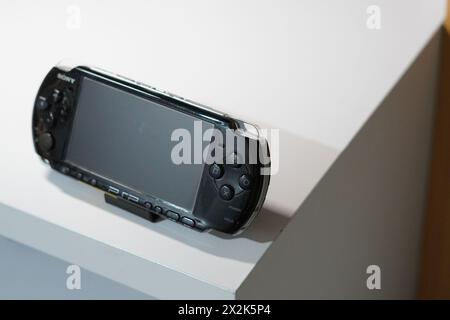 A black handheld game console from Sony called PSP on a white table ...