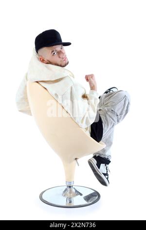 Rapper in yellow jacket sits on yellow chair and looks at camera ...
