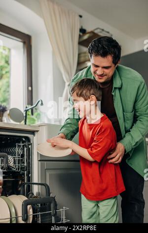 Cleaning, washing dishes and a father with a child in the kitchen for ...