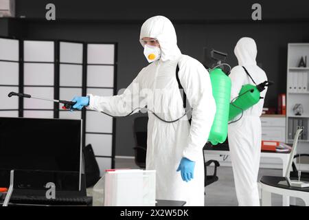 Male workers disinfecting in office Stock Photo - Alamy