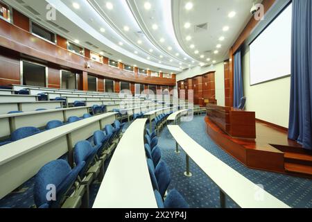 MOSCOW - AUGUST 18: Desks and blue seats in empty university auditorium ...