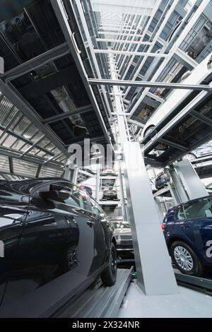 Bottom view multi-story car park building with blue sky view in center ...