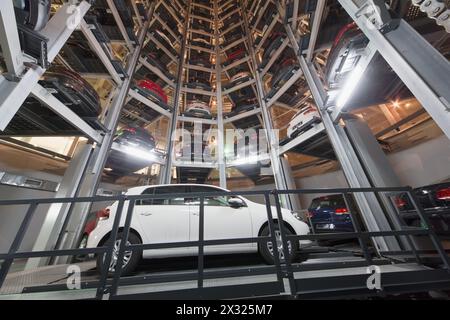 Bottom view multi-story car park building with plane flying above ...