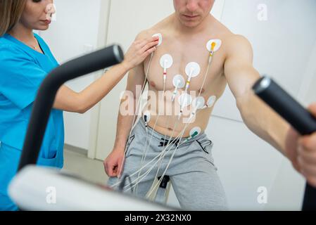 A patient undergoing a cardiac test with electrodes attached to their ...