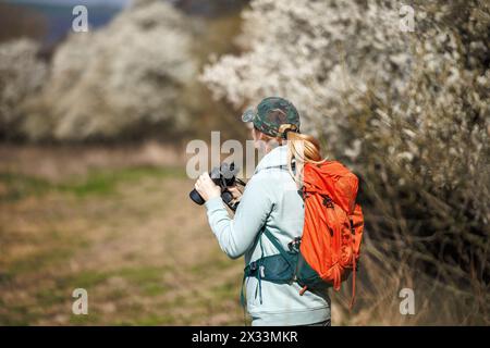 Bird watching. Woman ornithologist with binoculars observes birds ...
