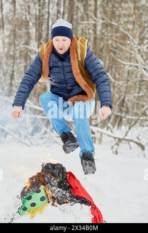 A man jumps over a bonfire as people celebrate Chaharshanbe Souri, or ...