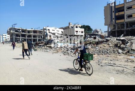 Palestinians walk amid buildings destroyed by Israeli air and ground ...