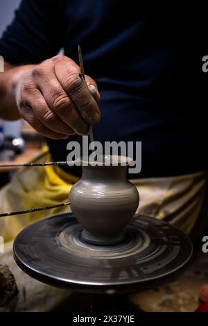 A potter making ceramic pottery inspired by ancient Greek amphorae in ...