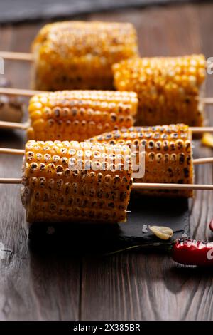 Slate tray with Pieces of Grilled corn on the cob on kitchen table ...