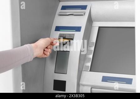 Woman inserting credit card into grey cash machine, closeup Stock Photo ...