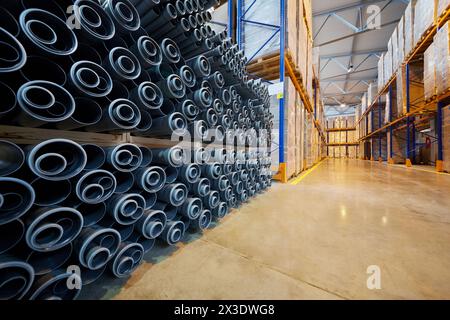Warehouse with plastic pipes and cardboard boxes on shelves at factory ...