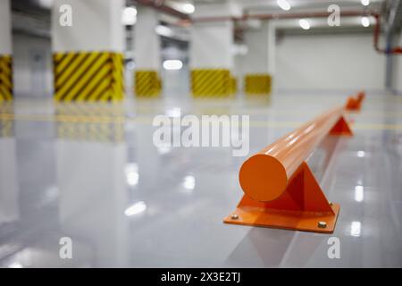 Mounted orange metal wheel stopper at underground parking, shallow dof ...