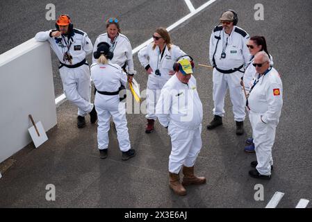 A group of marshals standing at the end of the pit lane at the 81st ...