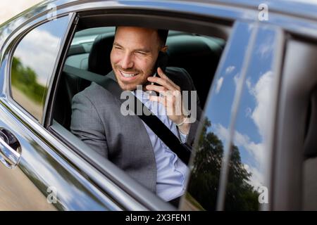 Man chuckles merrily during a car ride, enjoying a lively conversation ...