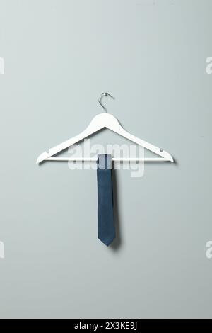 Hanger with blue necktie on light grey wall Stock Photo - Alamy