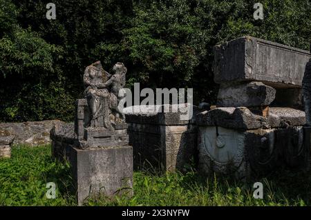 Headless woman and young girl embrace. Amid family monuments of the 1st ...