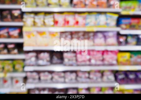 Abstract blur supermarket with variety of fast food snacks chips ...