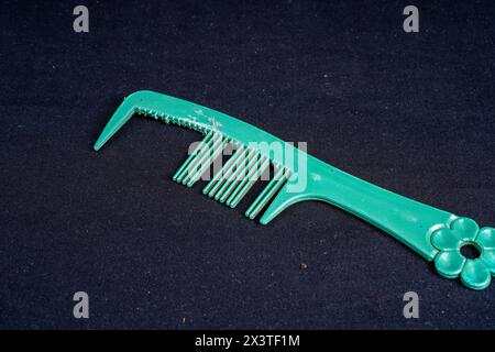 close up of a broken toothed comb on a black background with empty ...