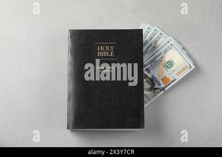 Holy Bible and money on grey table, top view Stock Photo - Alamy