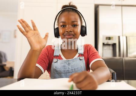 girl doing homework on a wooden table and there was a pile of books ...