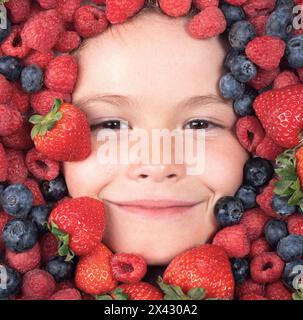 Vitamins from berrie. Child face with berry frame, close up. Berries ...
