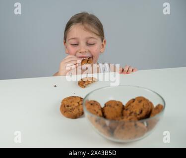 Little girl steals cookies from the table Stock Photo - Alamy