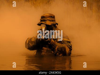 A bearded soldier performs a surveillance task in the water, walking ...