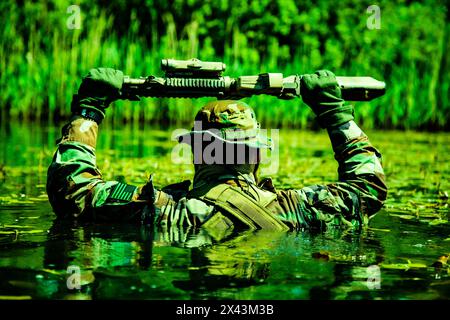 A camouflaged soldier walks through a swamp, submerging himself, his ...