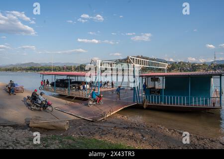 A Laotian ferry boat carries motorcycles, scooters, assorted vehicles ...