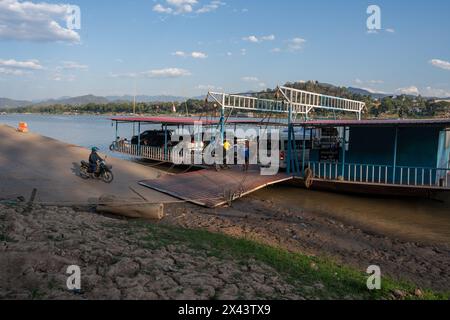 A Laotian ferry boat carries motorcycles, scooters, assorted vehicles ...