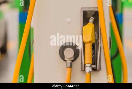 Closeup of gas pump handle with yellow rubberized cover inserted into ...