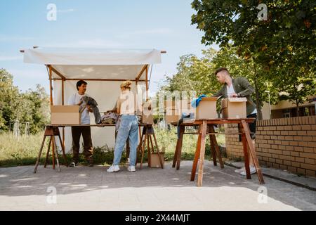 Group of young volunteers working at charity center. Woman smiling ...