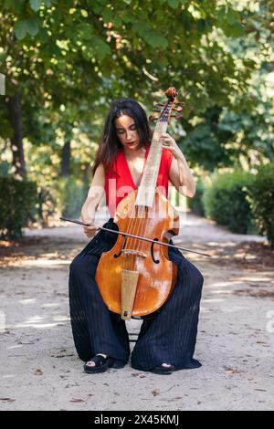 Young woman giving a cello concert on an outdoor stage in a park Stock ...