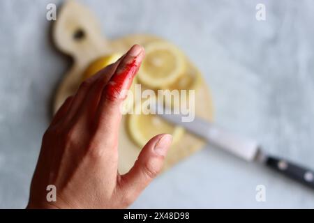 Female hands cuts lemon for making lemonade on white wooden background ...