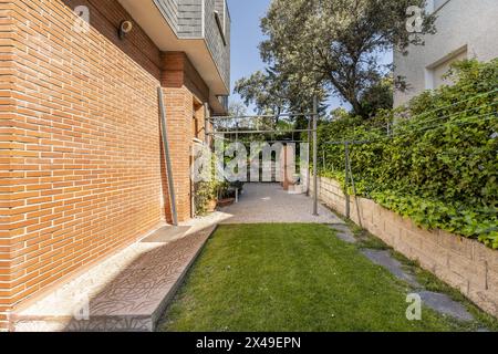 Perimeter garden with tiled path around a single-family house with ...