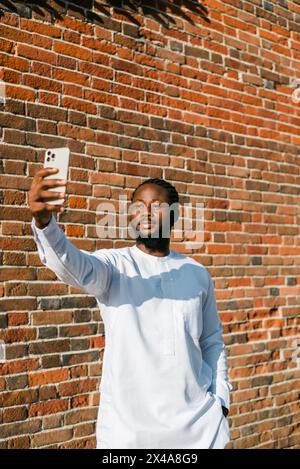 Young urban man with smarphone outdoors on background of St Basils ...